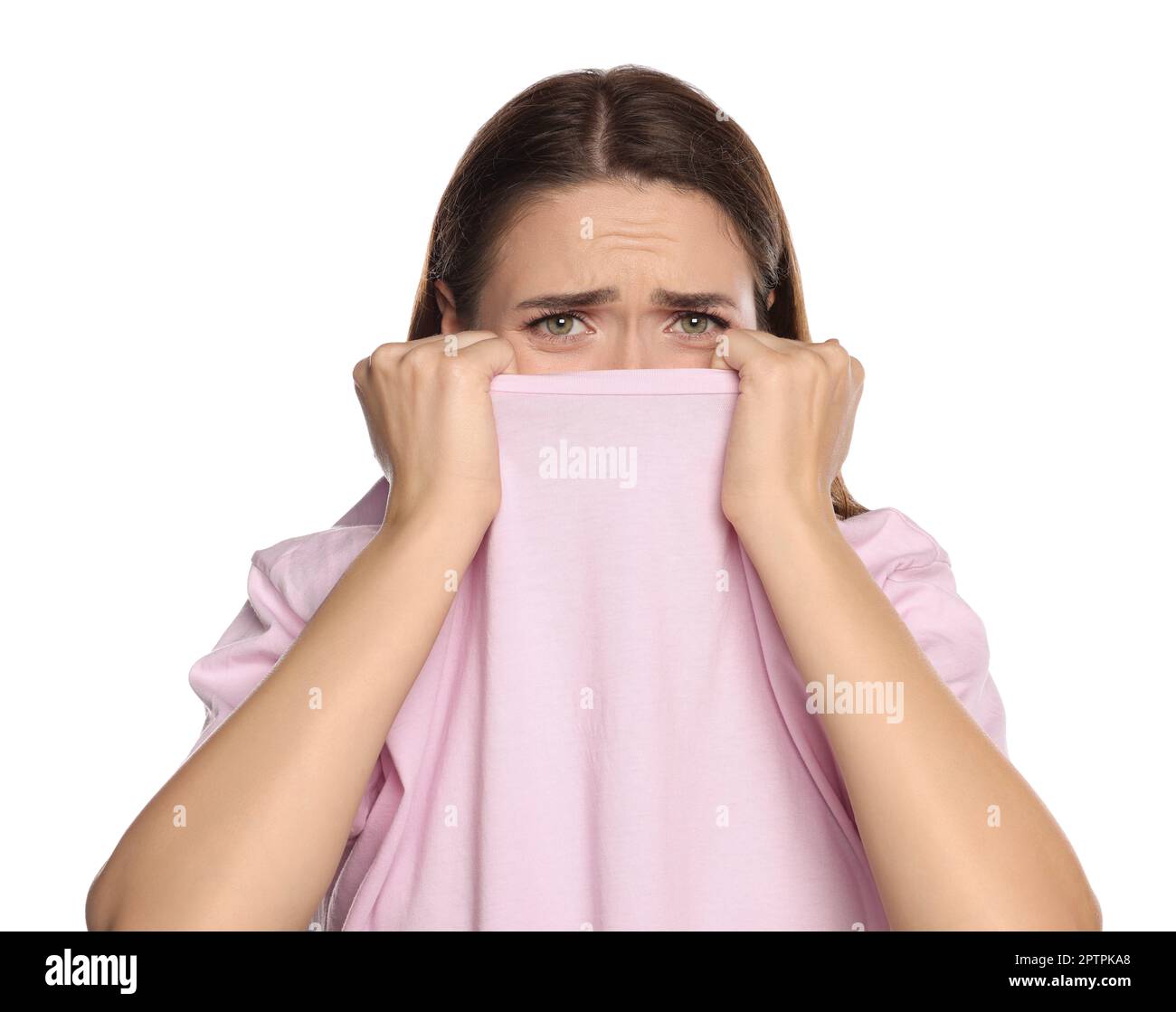 Embarrassed young woman covering face with shirt on white background ...