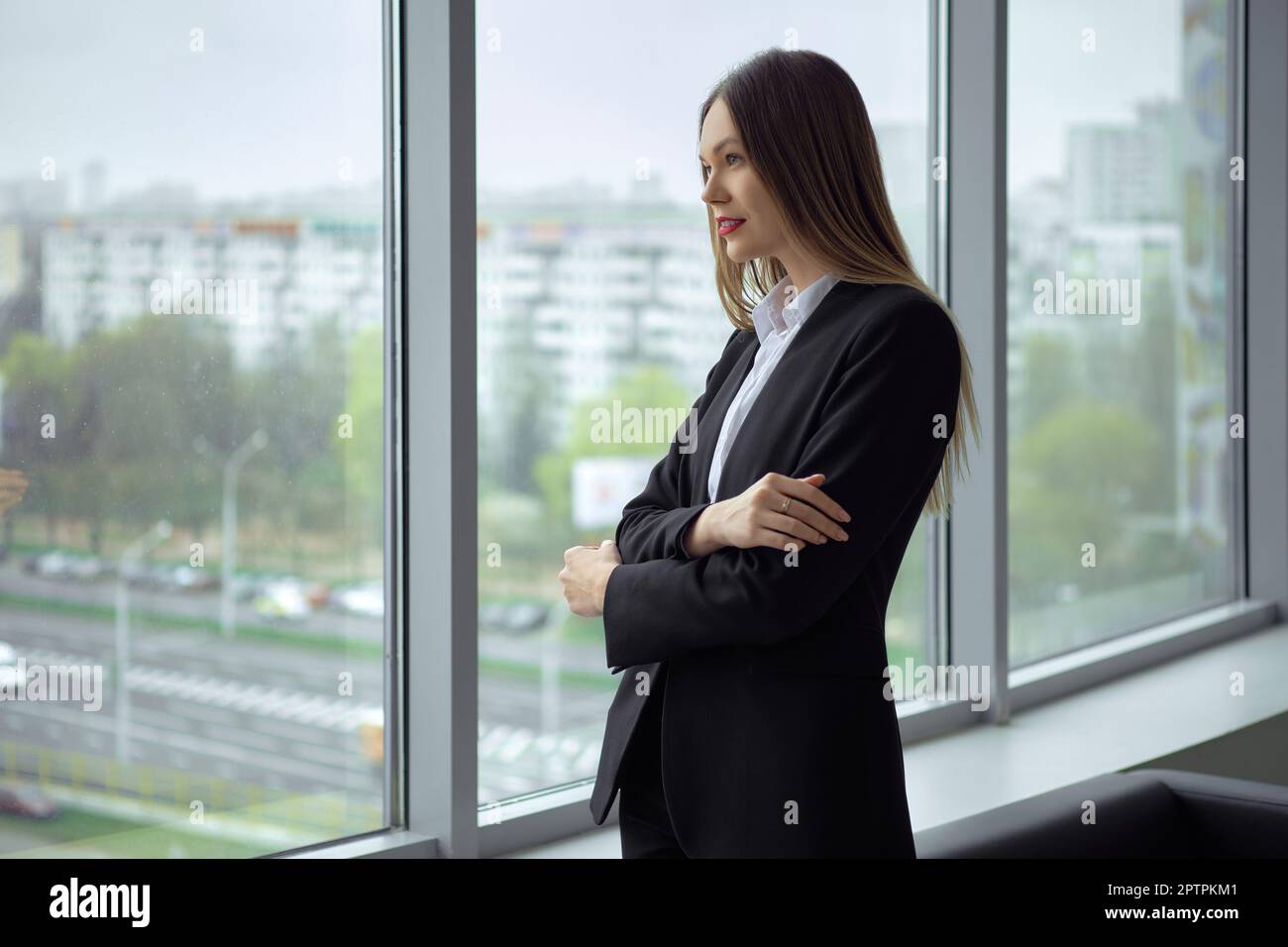 Beautiful business lady standing thoughtfully by the window Stock Photo ...
