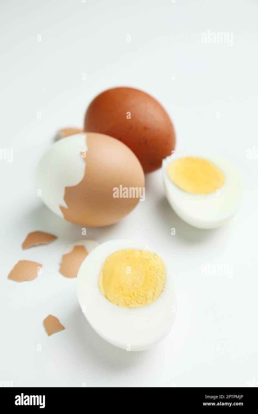 Hard boiled eggs and pieces of shell on white background Stock Photo ...