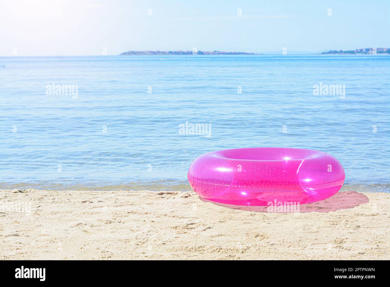 Bright inflatable ring on sandy beach near sea. Space for text Stock ...