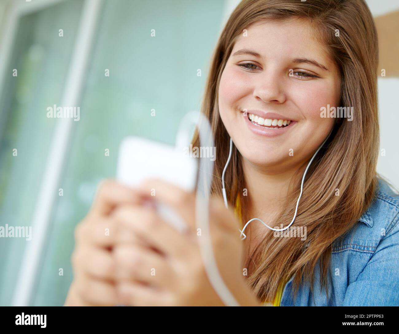 Music gets her amped. A pretty teenager choosing a song on her mp3 ...