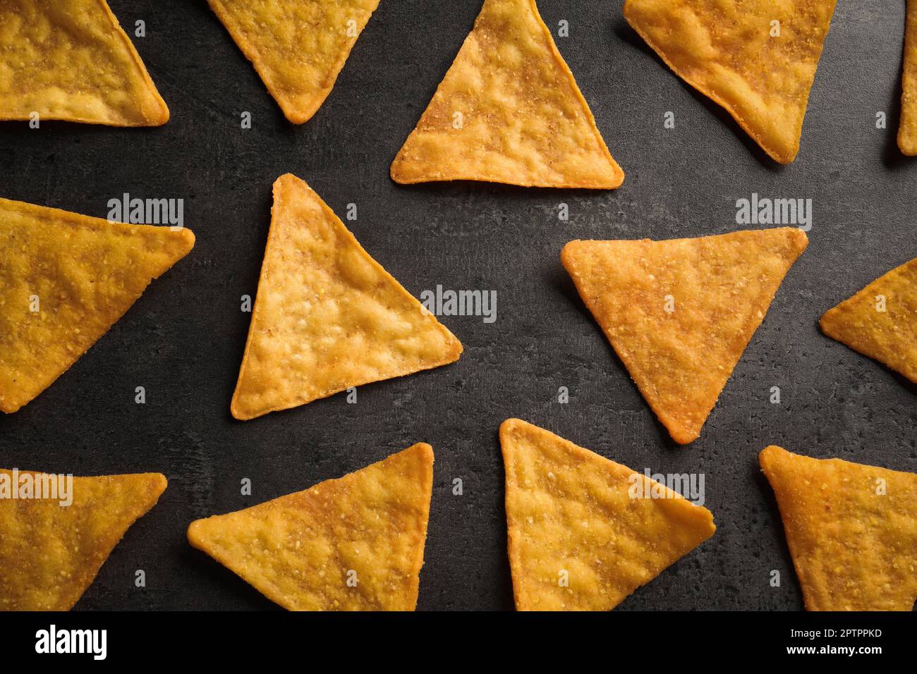 Flat lay composition of tasty tortilla chips (nachos) on grey table ...
