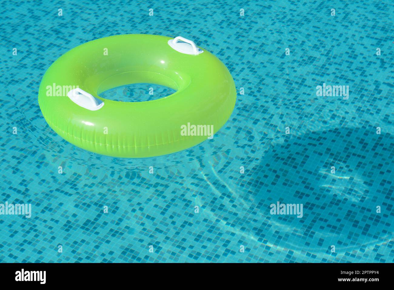 Light green inflatable ring floating in swimming pool. space for text ...