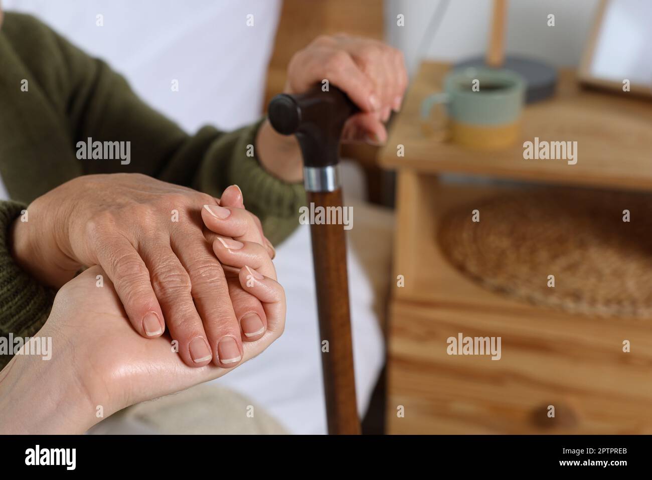 Caregiver and elderly woman with walking cane at home, closeup Stock ...