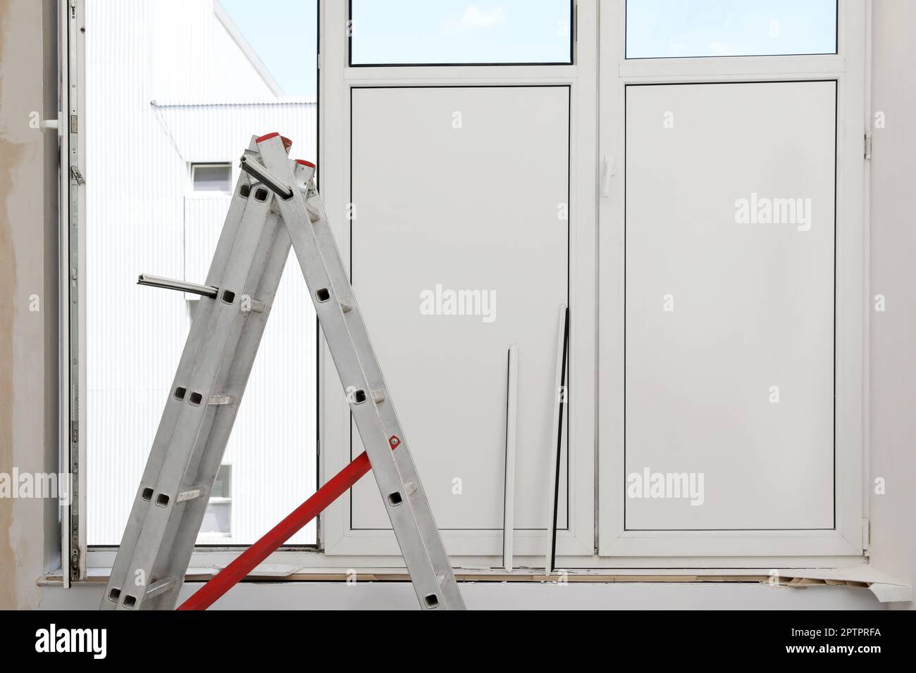 Folding ladder near open window indoors. Double glazing installation ...