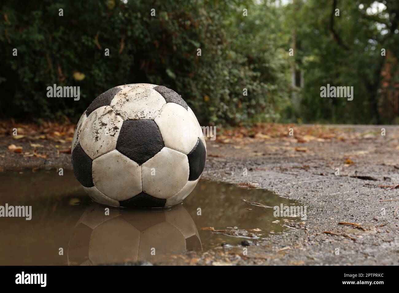 Dirty soccer ball in muddy puddle, space for text Stock Photo - Alamy
