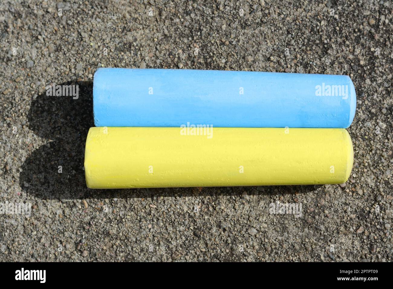 Yellow and light blue chalk sticks on asphalt, flat lay Stock Photo - Alamy