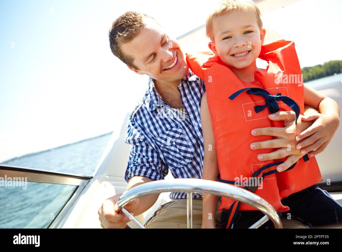 Two boys and a boat. Young father and his son riding in a speedboat ...