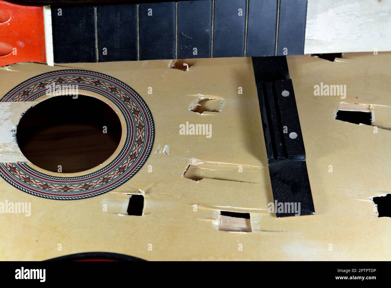 A broken wooden old classic guitar with damaged strings chords ...