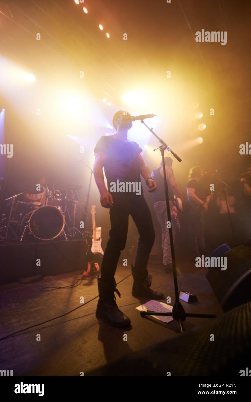 Music, rock and stage with man and microphone singing for concert ...