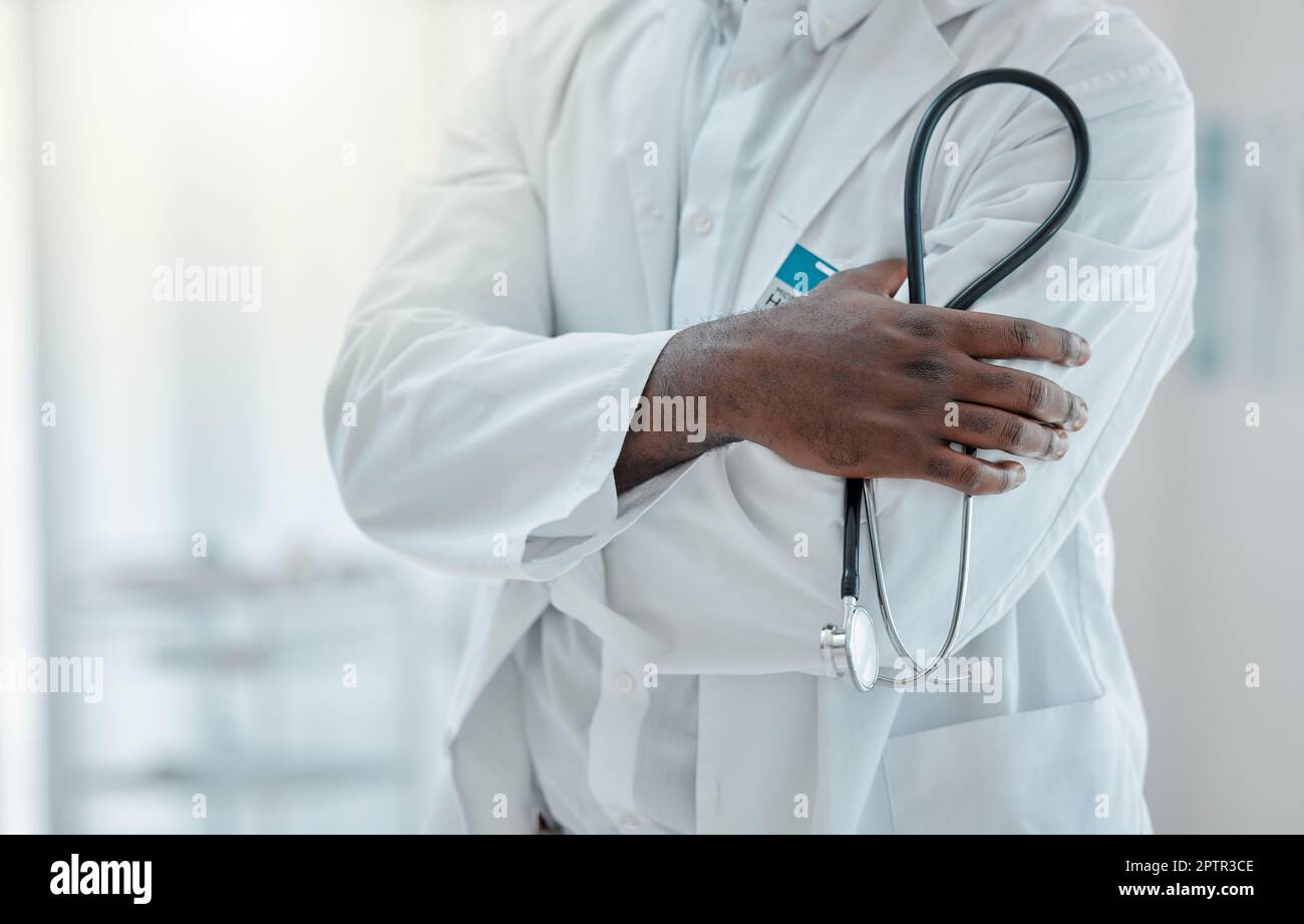 Proud doctor standing with their arms crossed and holding a stethoscope ...