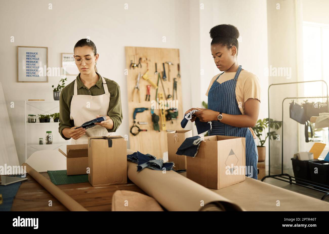 Two colleagues unpacking boxes. Fashion designers unpack stock order ...