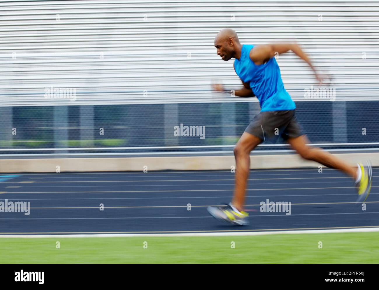 Running at full speed. Slightly blurred full length side view of a male ...