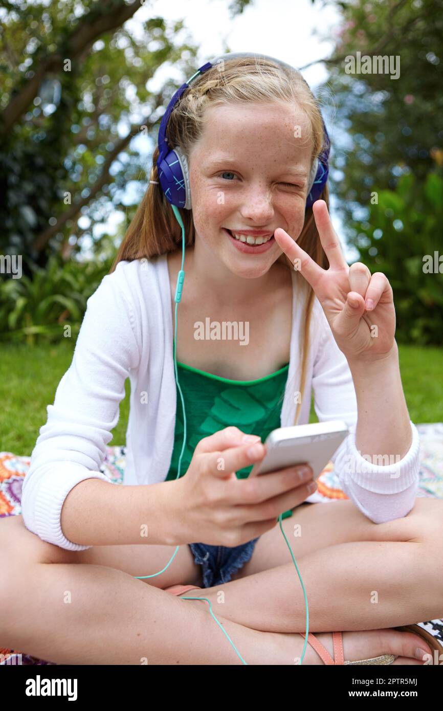 Listening to some cool tunes. a young girl listening to music on her ...