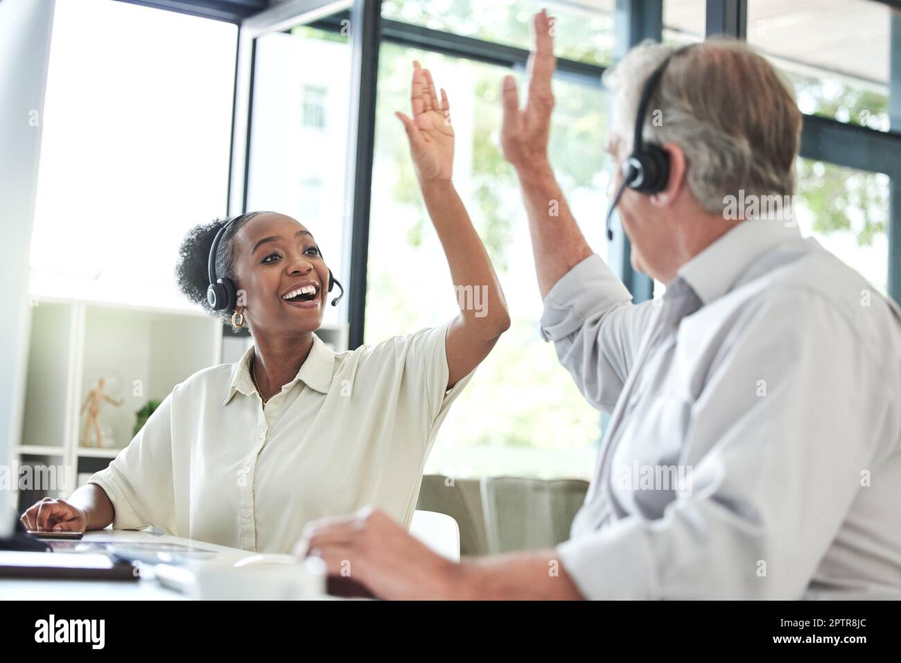 Weve got this. two call centre agents sitting together and giving each ...