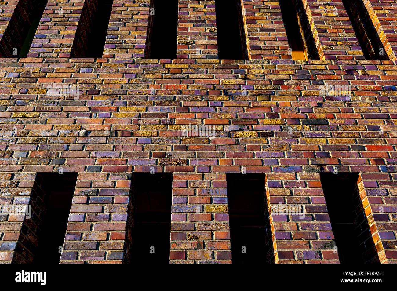 House wall made of reddish bricks with window openings in bottom view ...