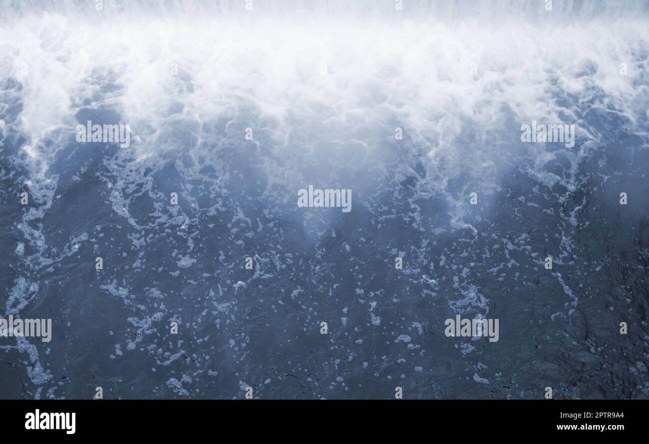 Dam to regulate the water level in the river. Falling water monochrome ...