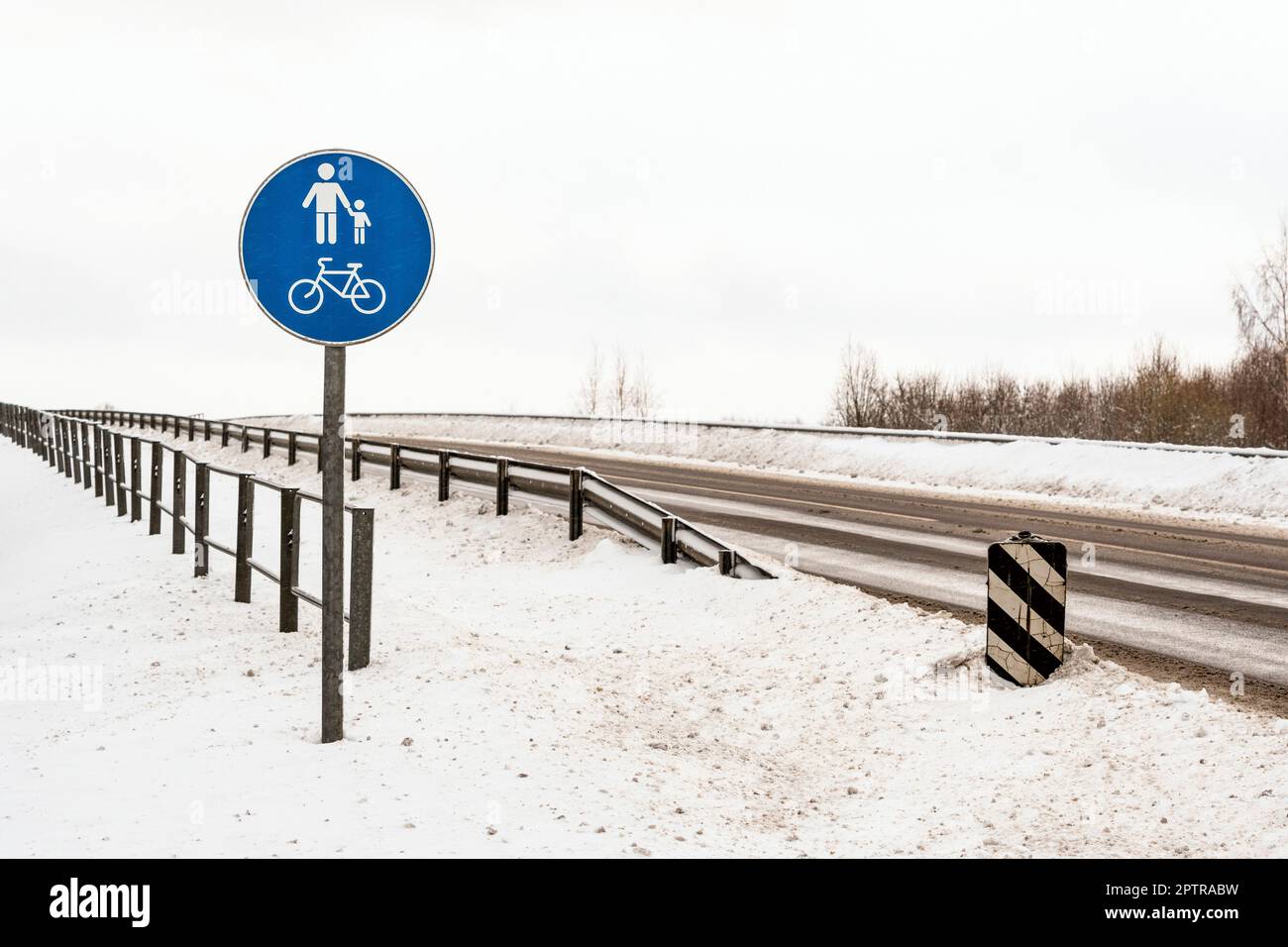 Bicycle path in winter under the deep snow. The bike season is closed ...