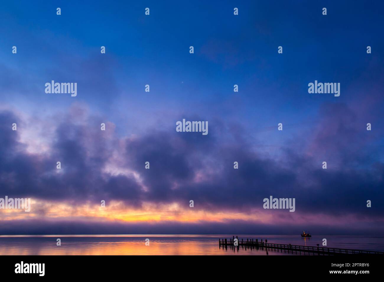 Sunset or sunrise on North Sea coast with rising water vapor forming ...