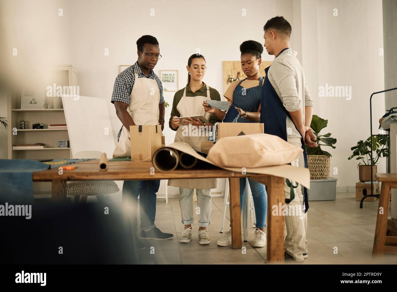 Creative teamwork, fashion and clothes making team looking at fabric at ...