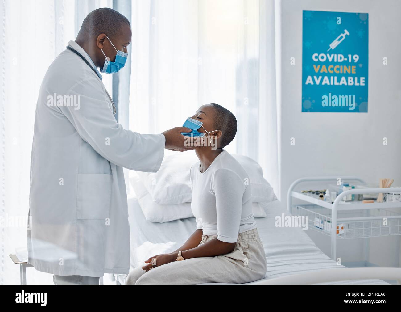 Doctor with patient in covid face mask doing examination of thyroid or ...