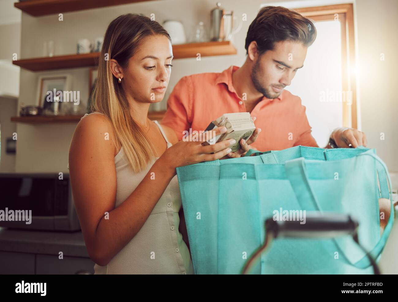 Groceries, plastic free and healthy couple unpacking after returning ...