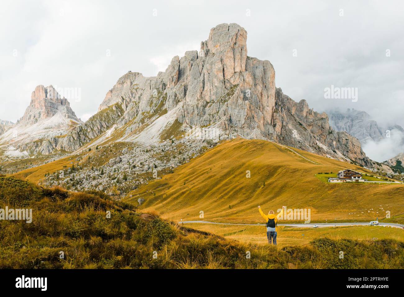 Hiker reaching hands to sky enjoys exploring mountain nature on Pass ...
