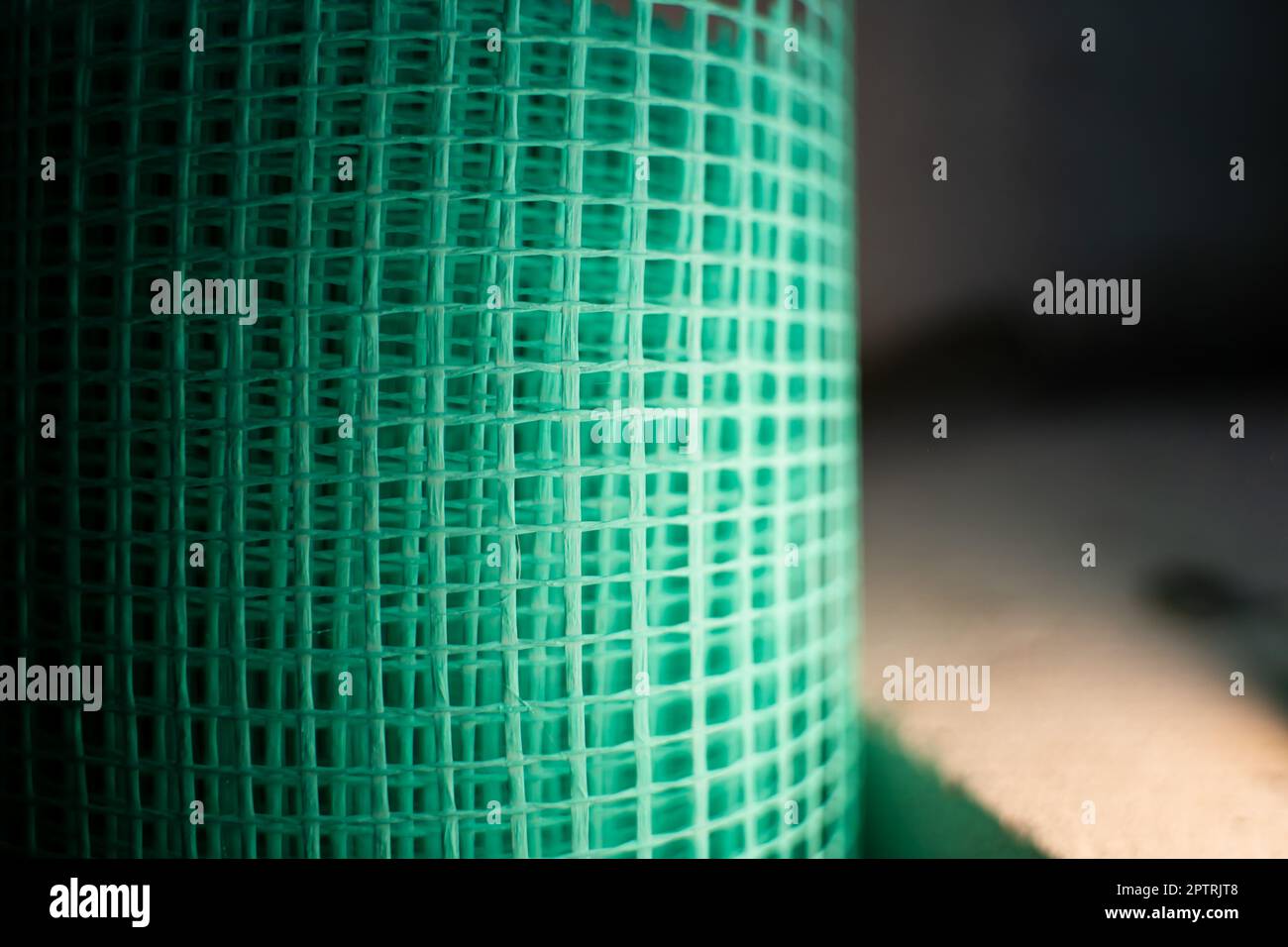 Green reinforcing mesh close-up. Facade fiberglass mesh on a blurred ...