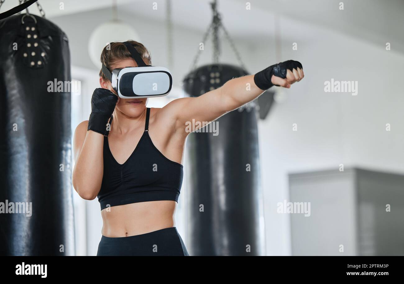 Healthy, fit and active boxing woman with a VR headset to access the ...