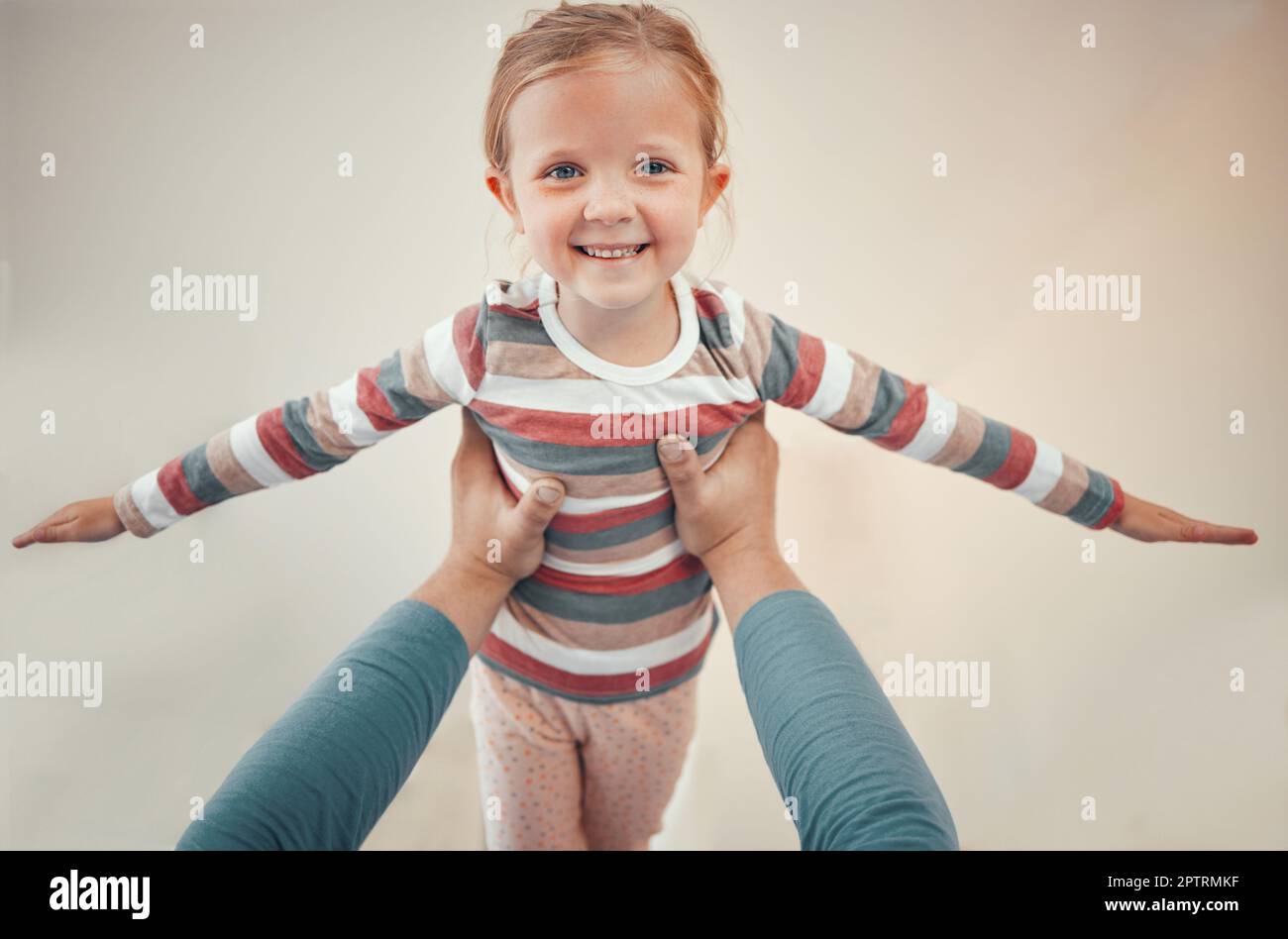 Adorable little girl pretending to fly with arms outstretched while ...