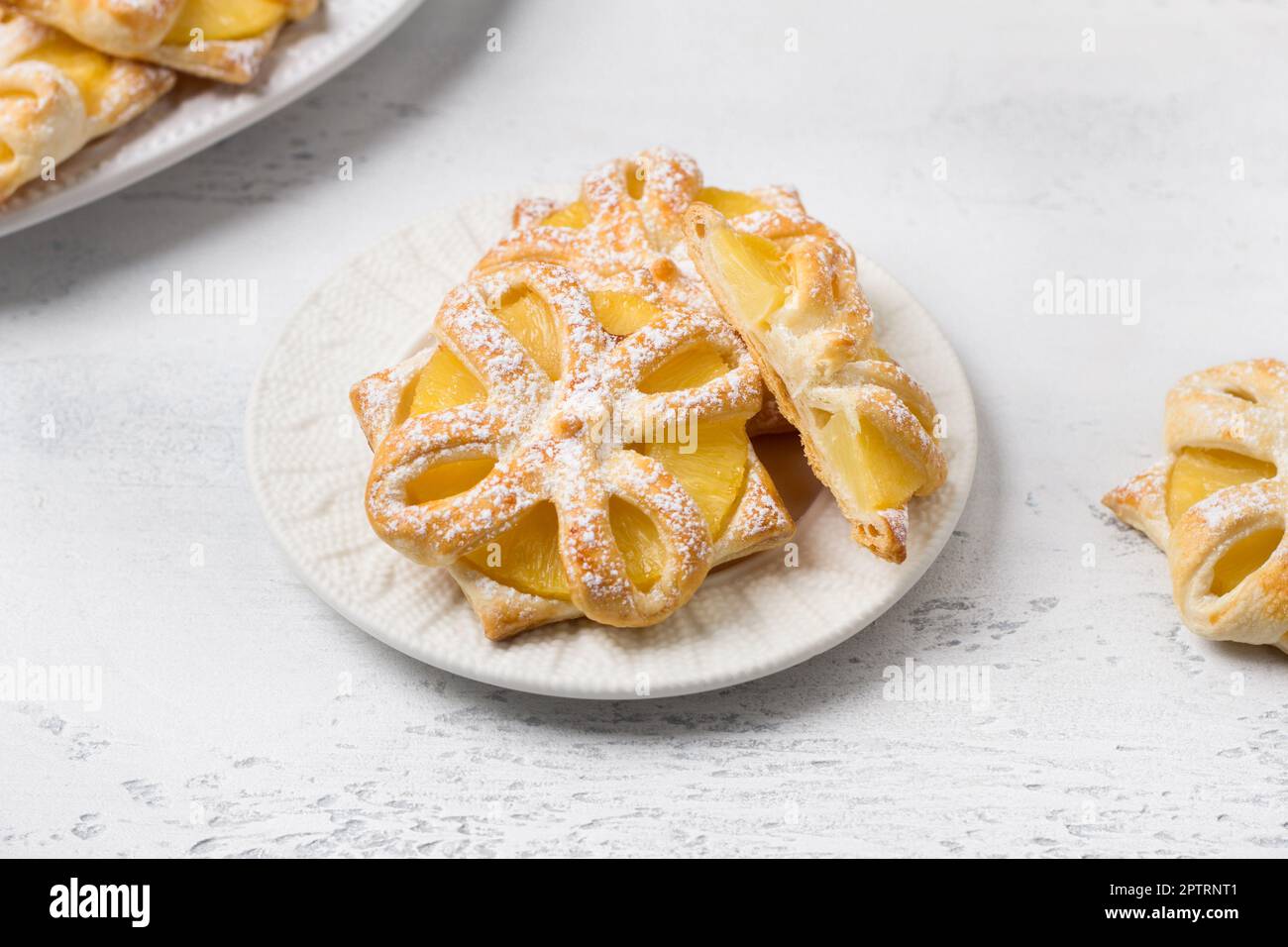 Baked pineapples in puff pastry sprinkled with powdered sugar on a ...