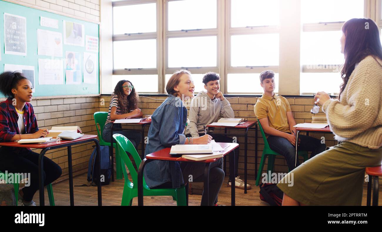 Teaching her students about life. a cheerful young teacher giving class ...