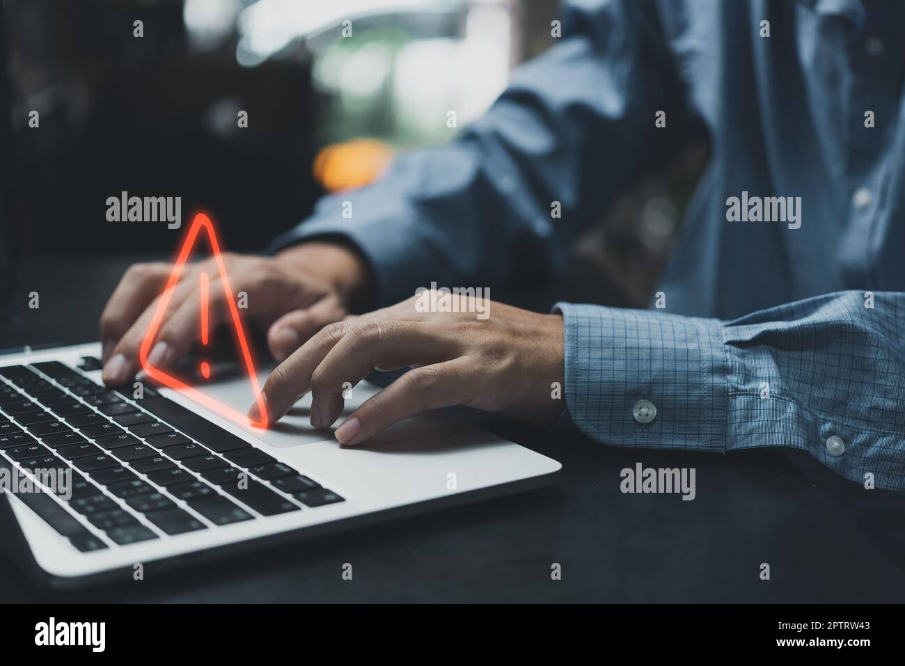 Businessman programmer, developer using laptop computer with triangle caution warning sign for ...
