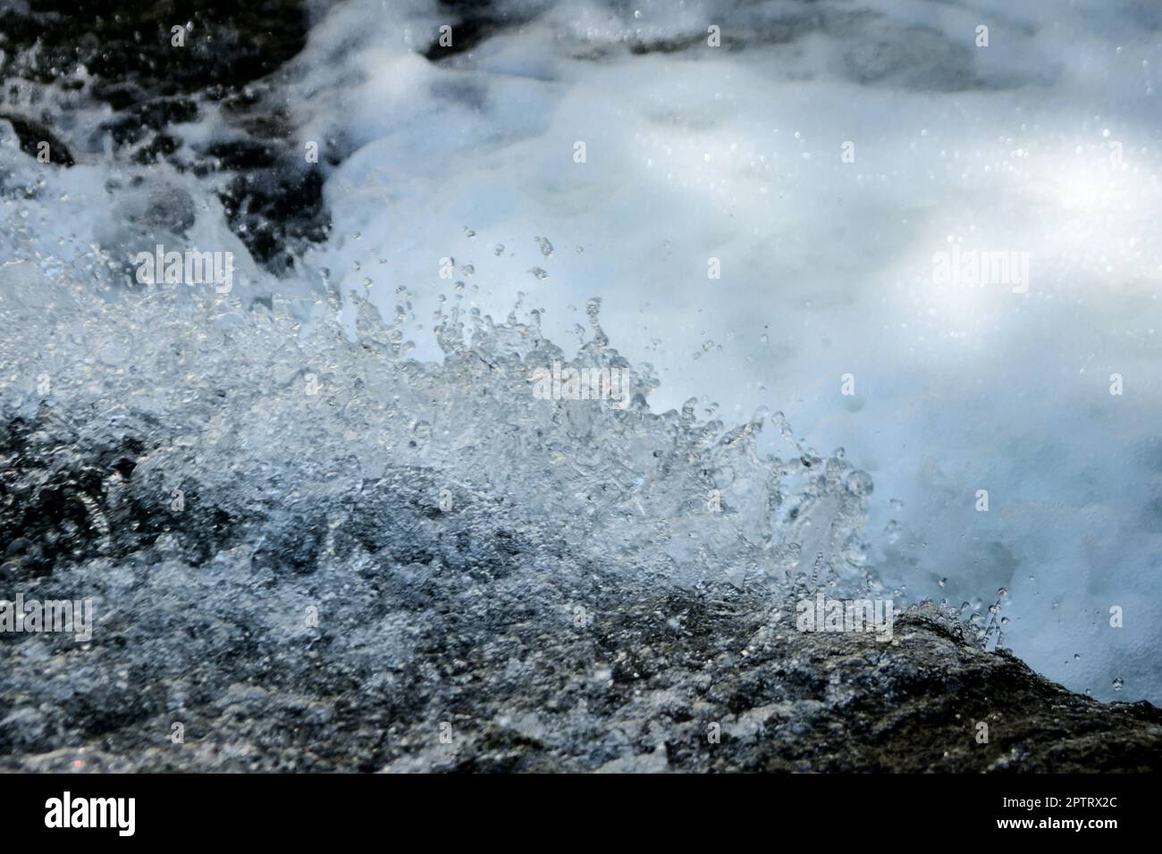 Clear, fresh stream of water splattering in a natural creek ...