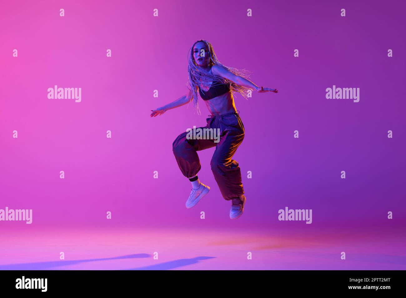 One dancer, woman wearing casual clothes jumping up in motion over ...