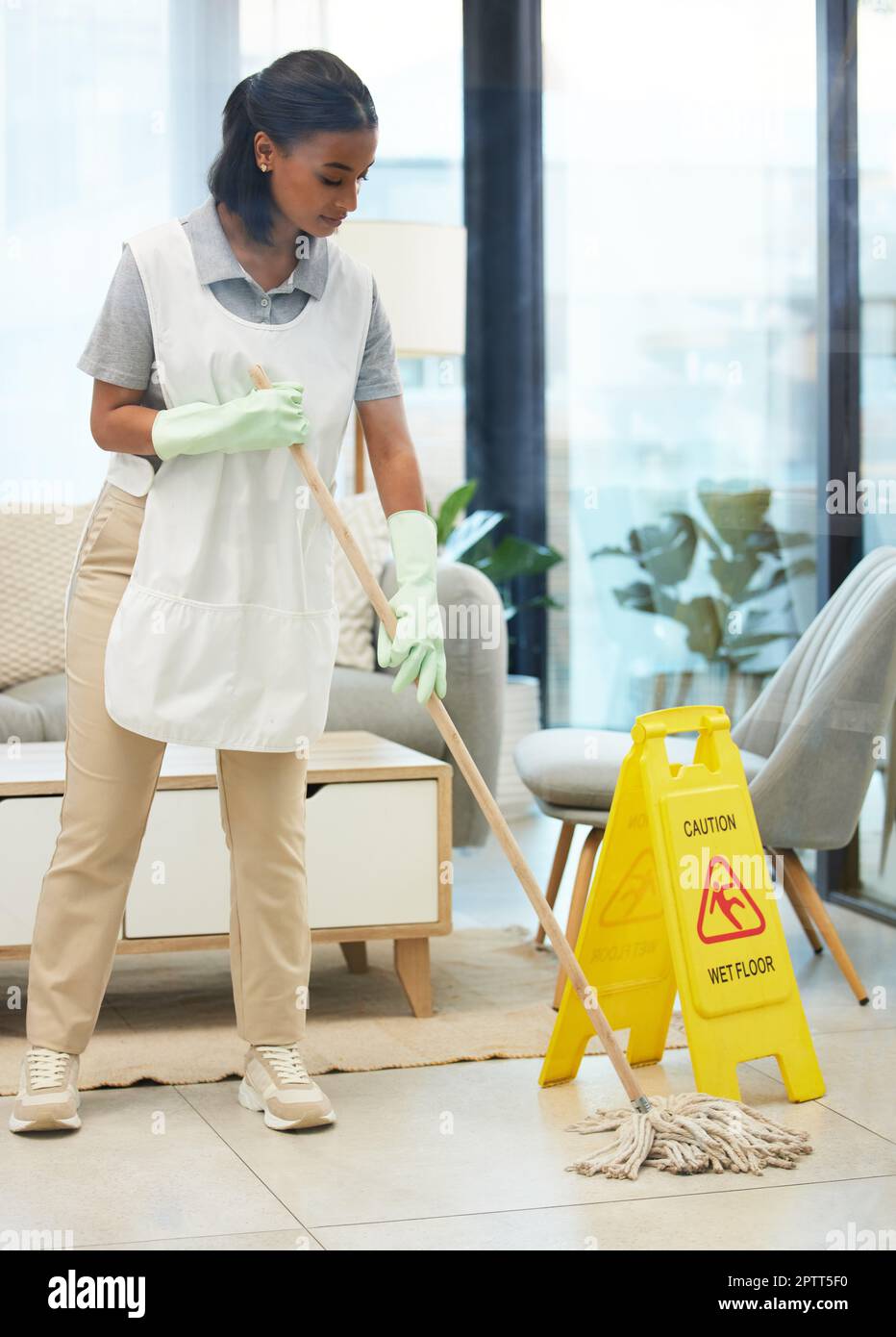 Shot of a young woman mopping the floor Stock Photo - Alamy