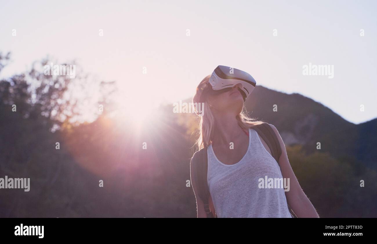 Woman hiking in a forest using a virtual reality headset to enhance the ...