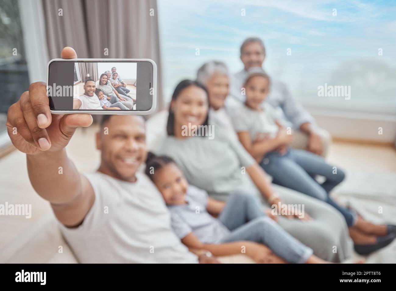 Happy and affectionate young mixed race family of six taking a selfie at home. Married couple ...