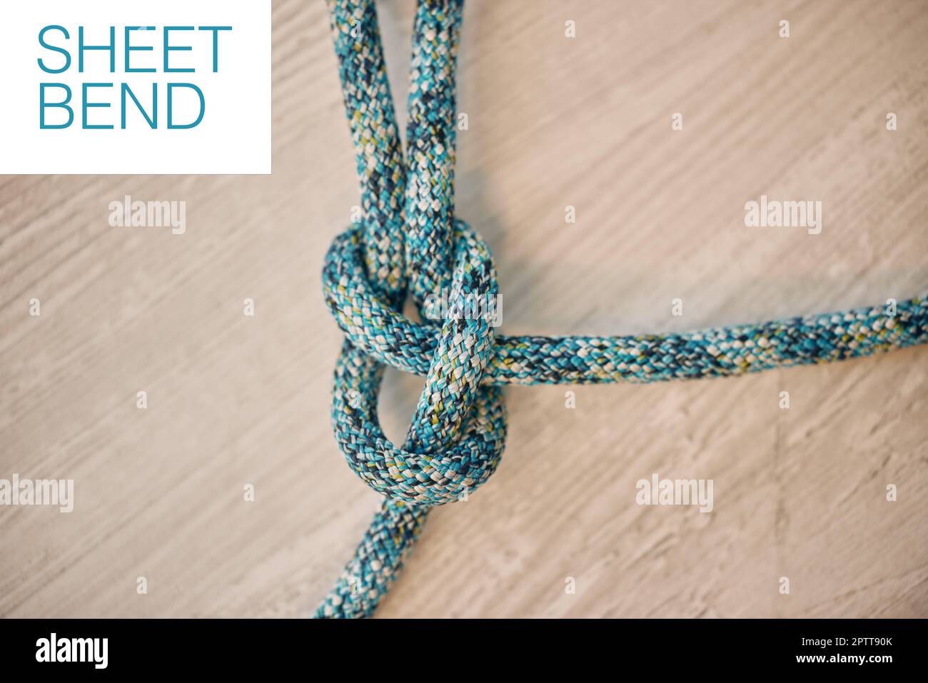 Above shot of hiking rope tied in a knot against a wooden background in ...