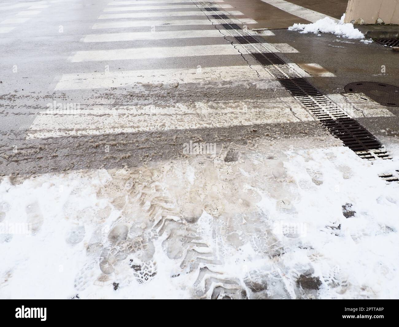 Snow, ice, slush and winter mud at a pedestrian crossing. The air ...