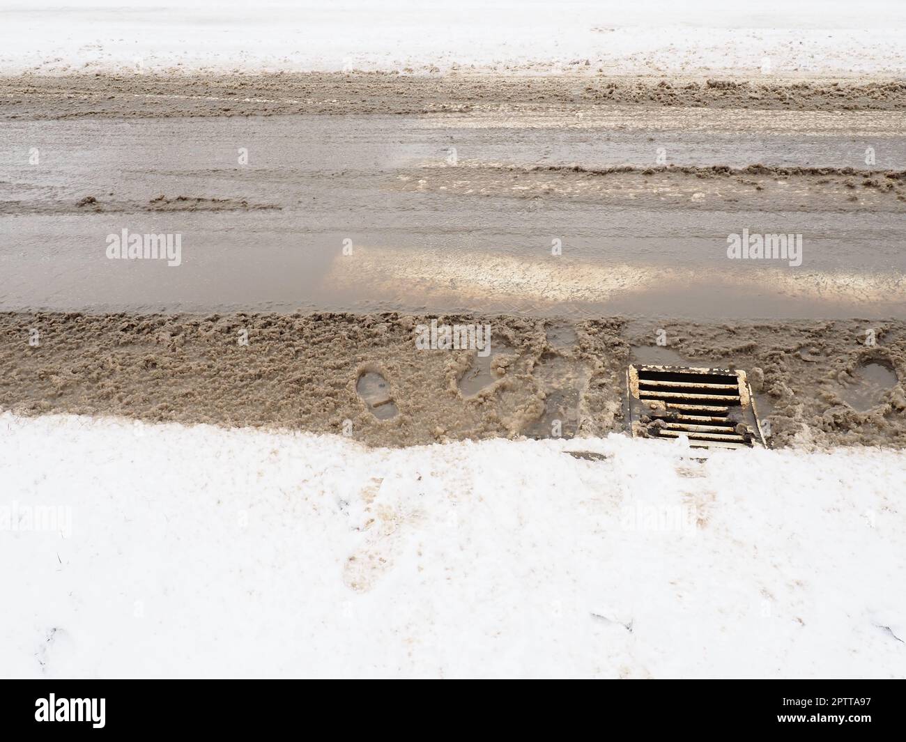 Snow, ice, slush and winter mud at a pedestrian crossing. The air ...