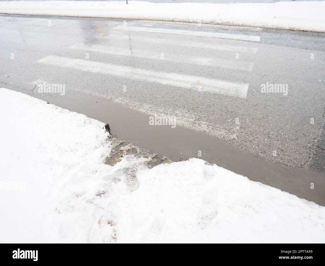 Snow, ice, slush and winter mud at a pedestrian crossing. The air ...