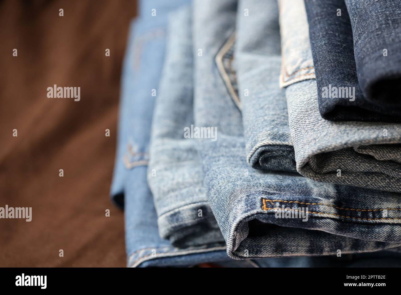 Many jeans in stack in wardrobe room. Row of pants denim jeans in ...