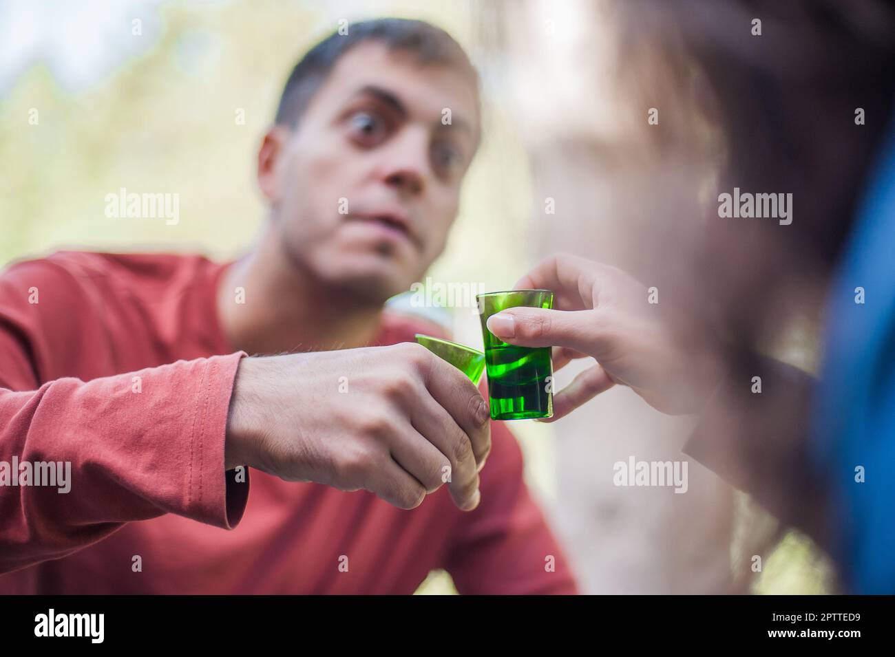Cheers. Very drunk couple, a boy and a girl, chug shot drink from small ...