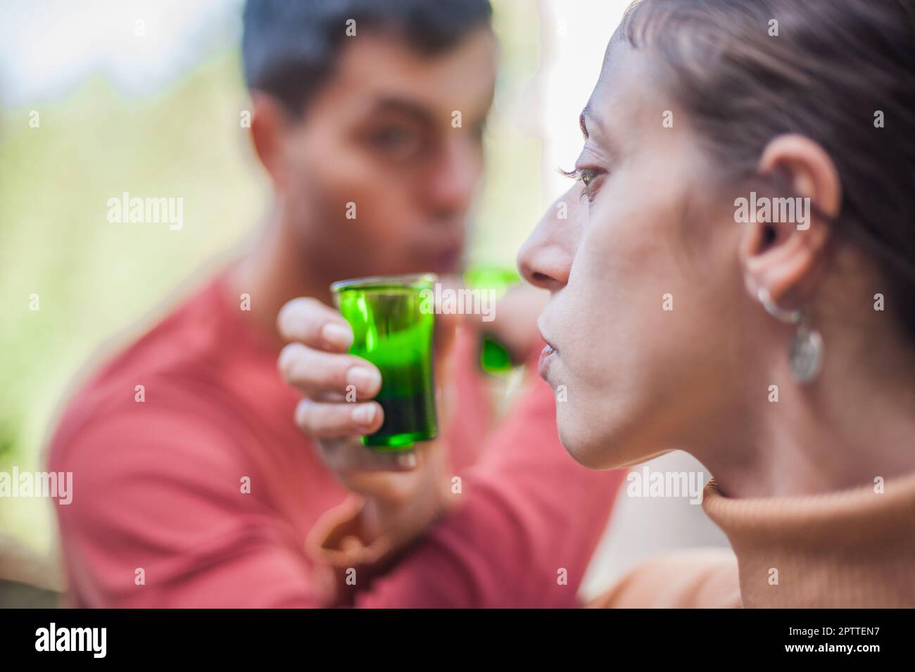 Cheers. Very drunk couple, a boy and a girl, chug shot drink from small ...