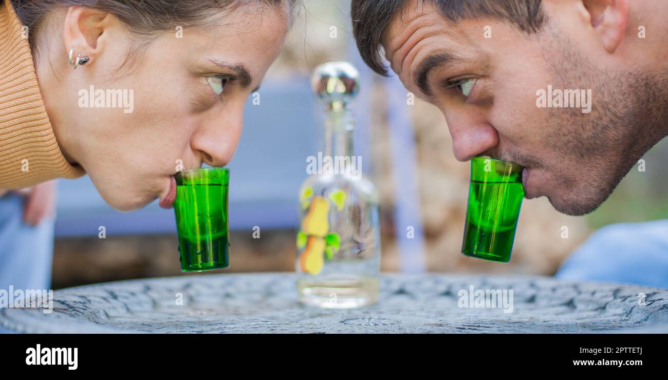 Cheers. Very drunk couple, a boy and a girl, chug shot drink from small ...