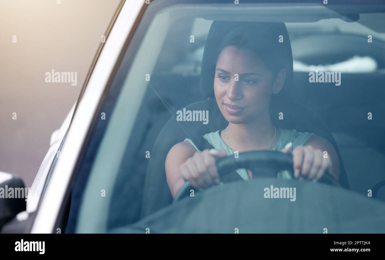 Cheerful mixed race woman driving her new car. Hispanic woman looking ...