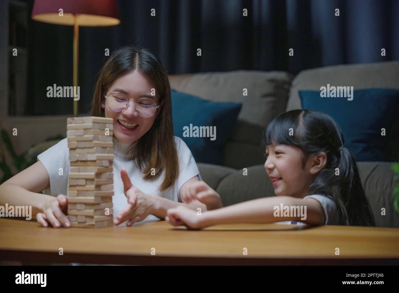 Smiling woman help teach child play build constructor of wooden blocks, Asian young mother ...