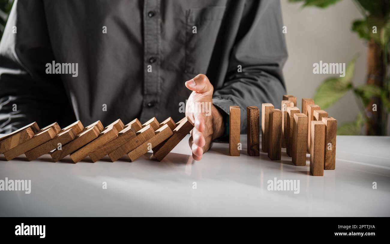 Business risk planning. Man hand blocks wood block from many row ...