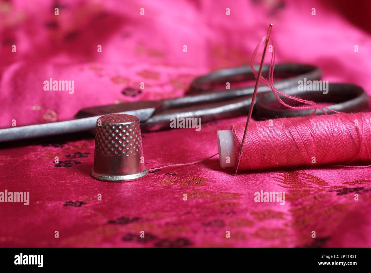 Spool of Pink Thread and Thimble on Vintage Pink Satin Stock Photo - Alamy